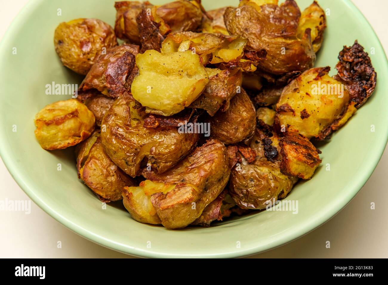 Baked smashed potato home-fries in server bowl Stock Photo - Alamy