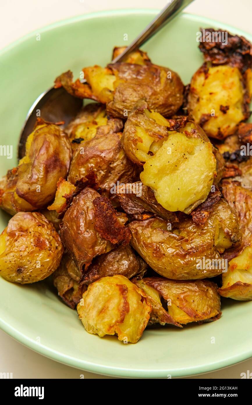 Baked smashed potato home-fries in server bowl Stock Photo - Alamy