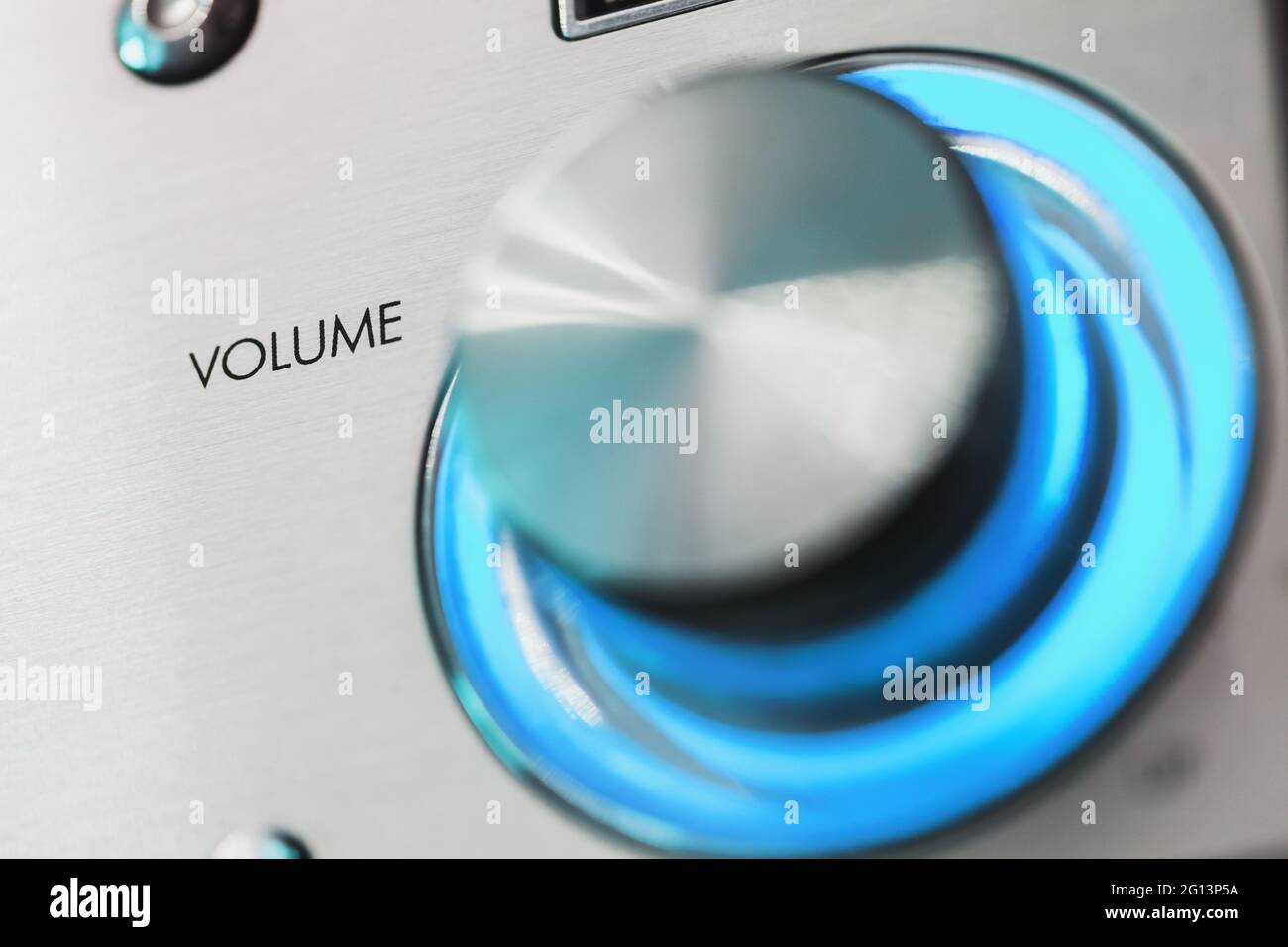 Shiny metallic volume control knob with blue LED illumination, close up ...