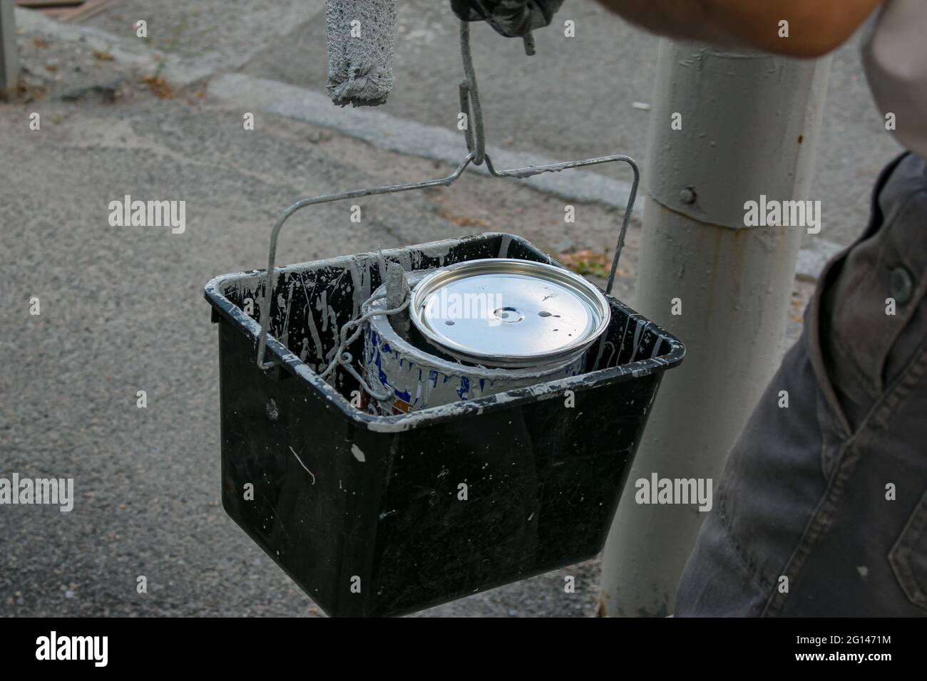 Working painters prepare paint for painting a traffic light pole. The ...