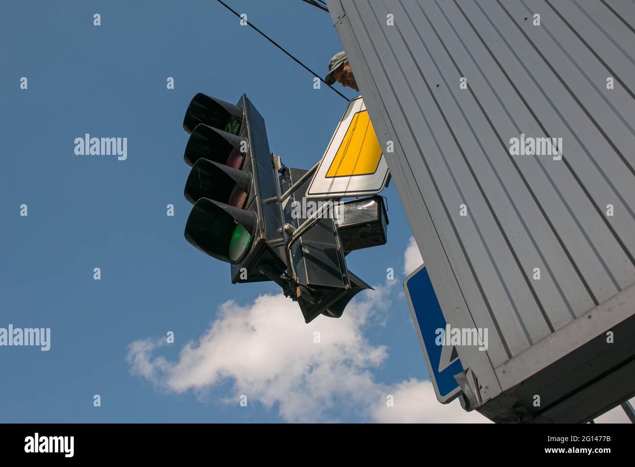 Workers of the city utilities are painting a working traffic light. An ...