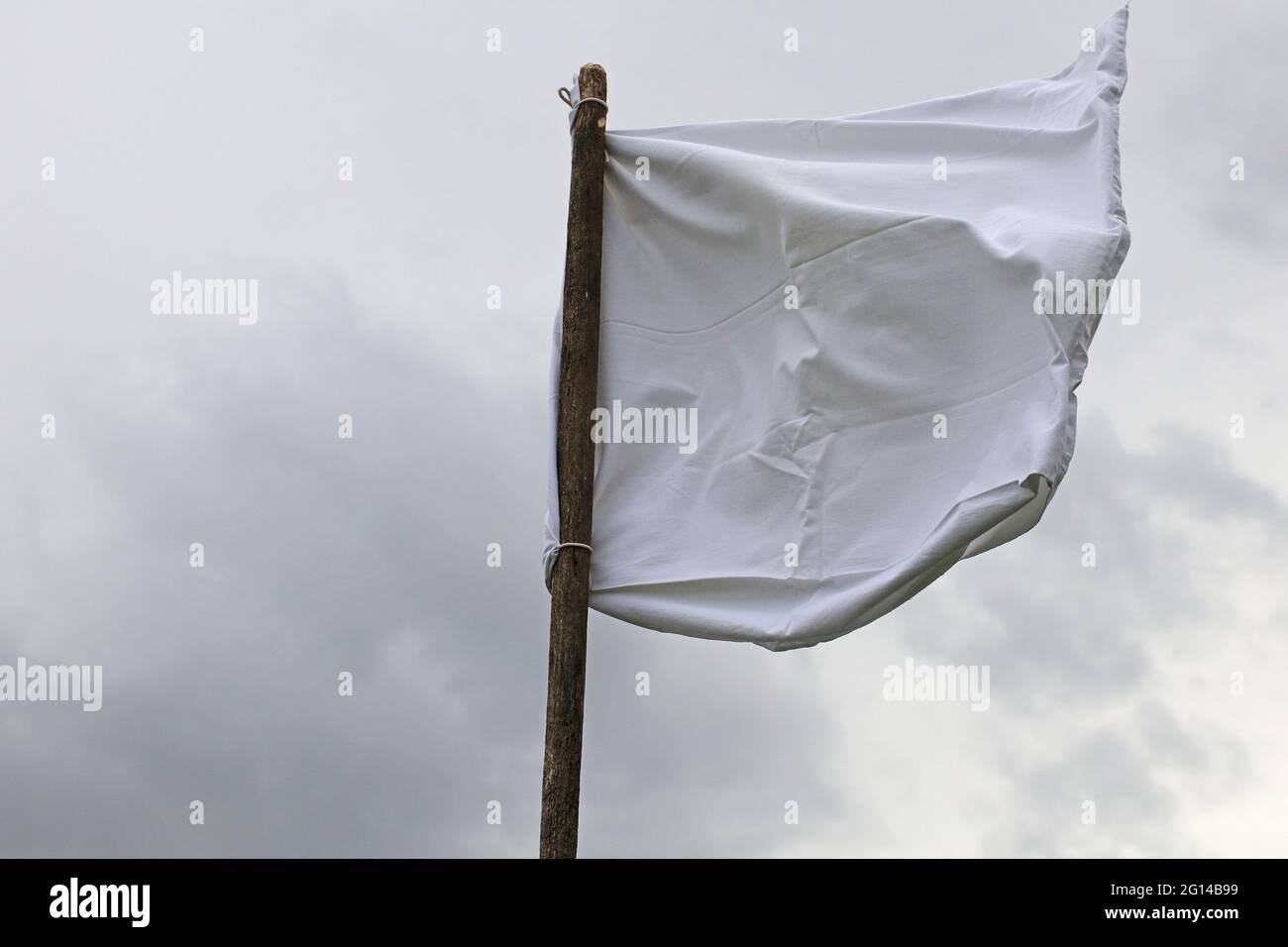 The white flag against the gray sky. Surrender concept Stock Photo - Alamy