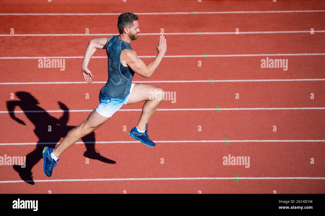 energetic athletic muscular man runner running on racetrack at outdoor ...