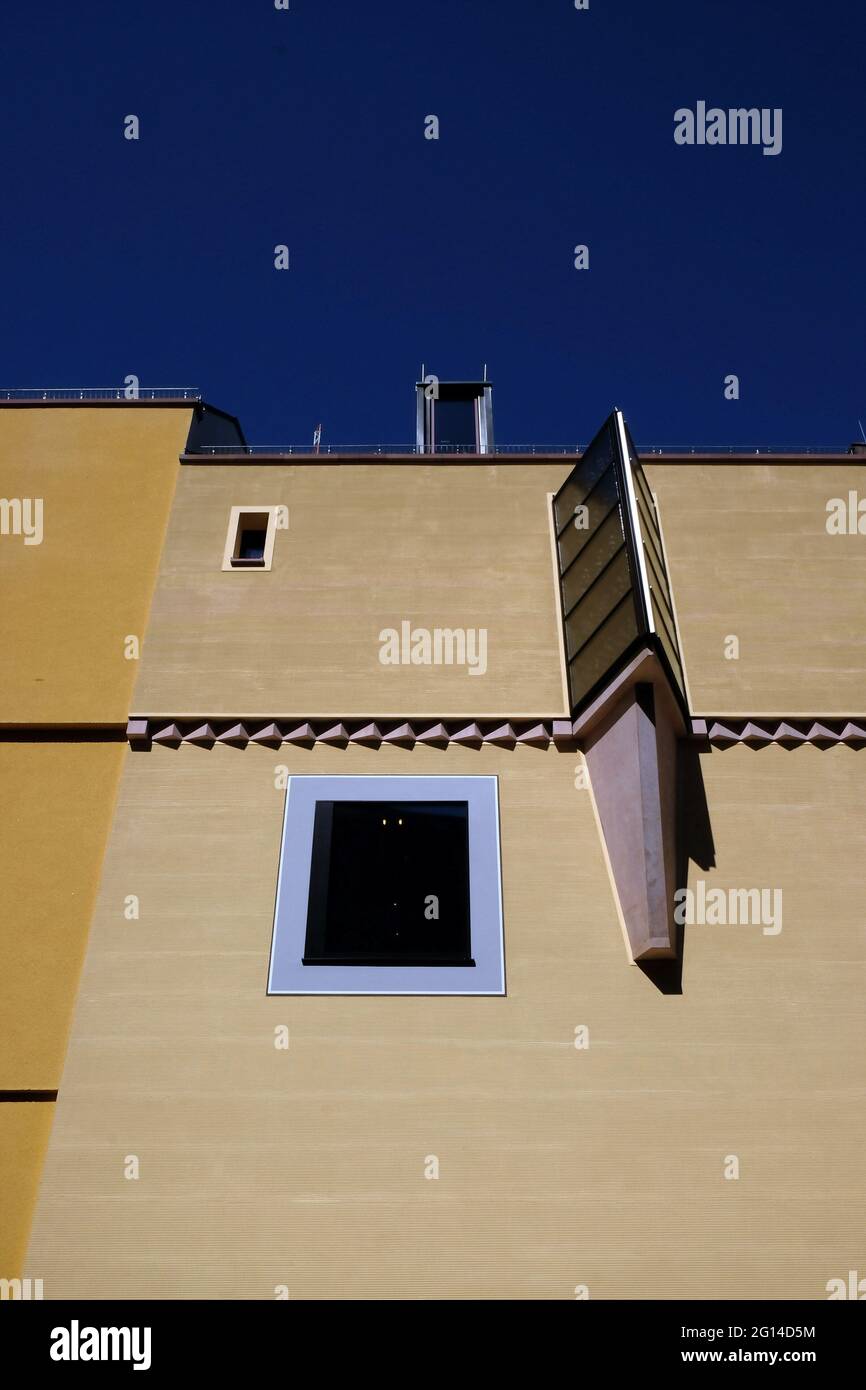 Low-angle shot of the facade of a modern yellow building against the ...