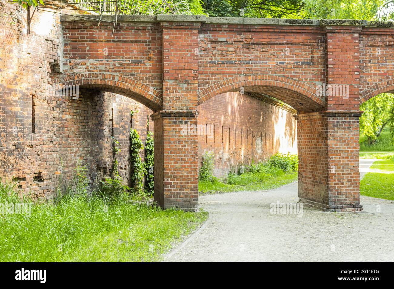 An arched red stone bridge in an old castle. View of the bridge with an ...