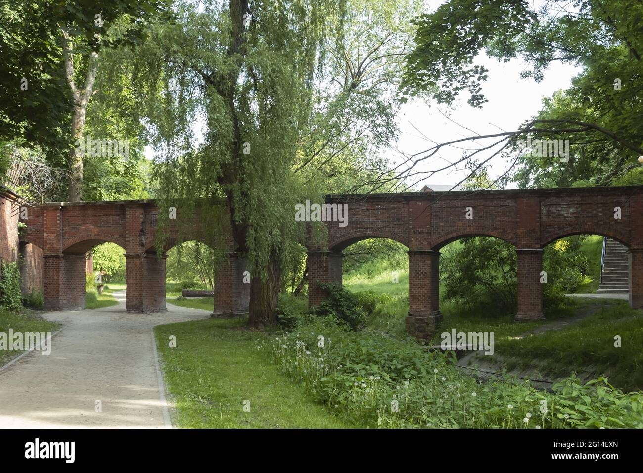 An arched red stone bridge in an old castle. View of the bridge with an ...
