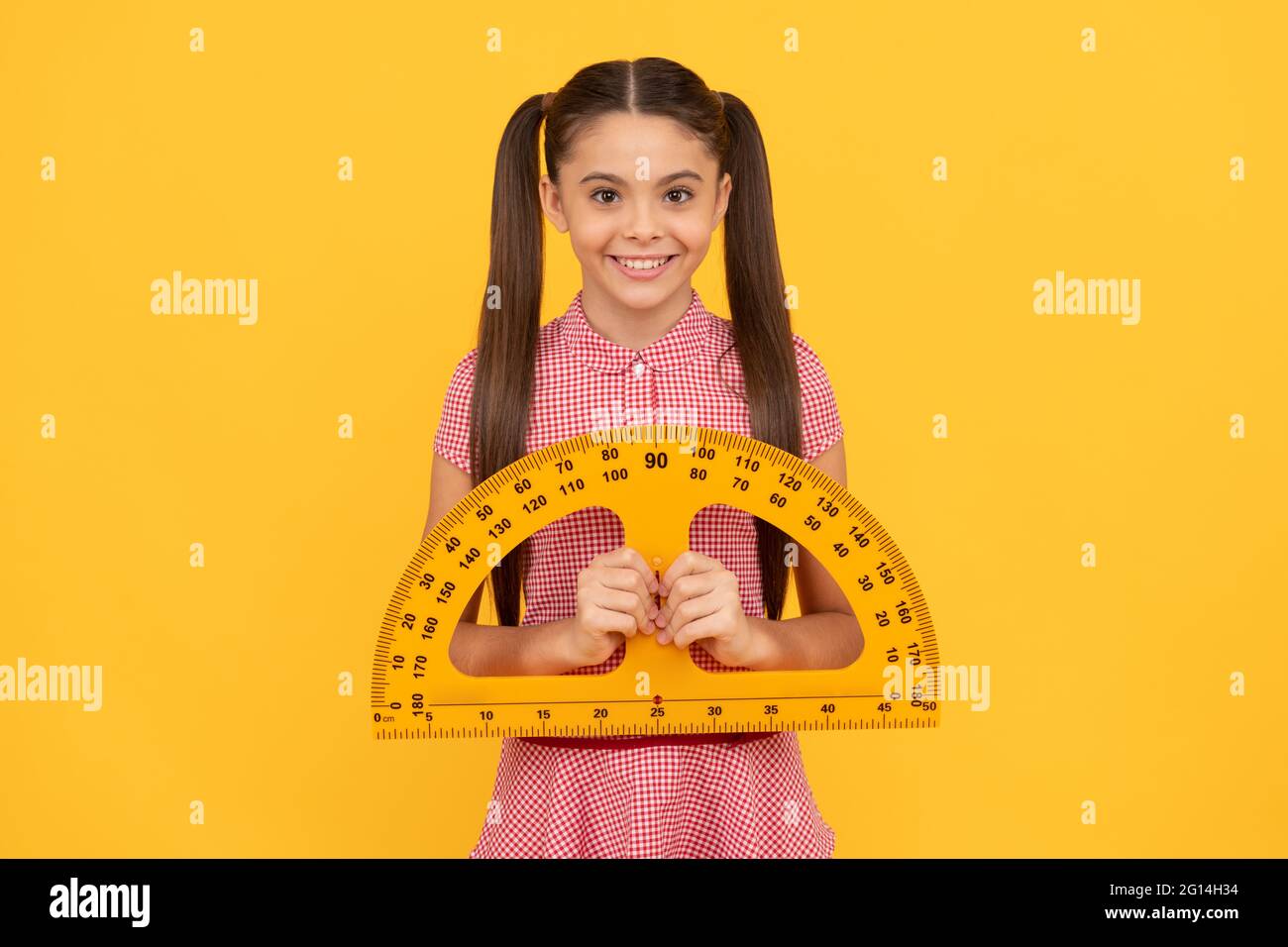 happy child hold school math tool protractor ruler on yellow background ...