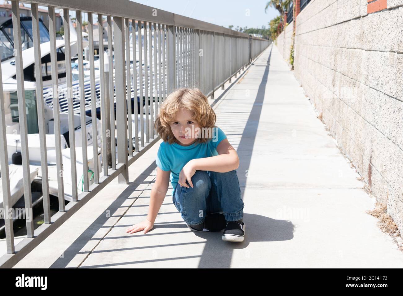 Boy child take short break hunkering down on promenade, rest Stock ...