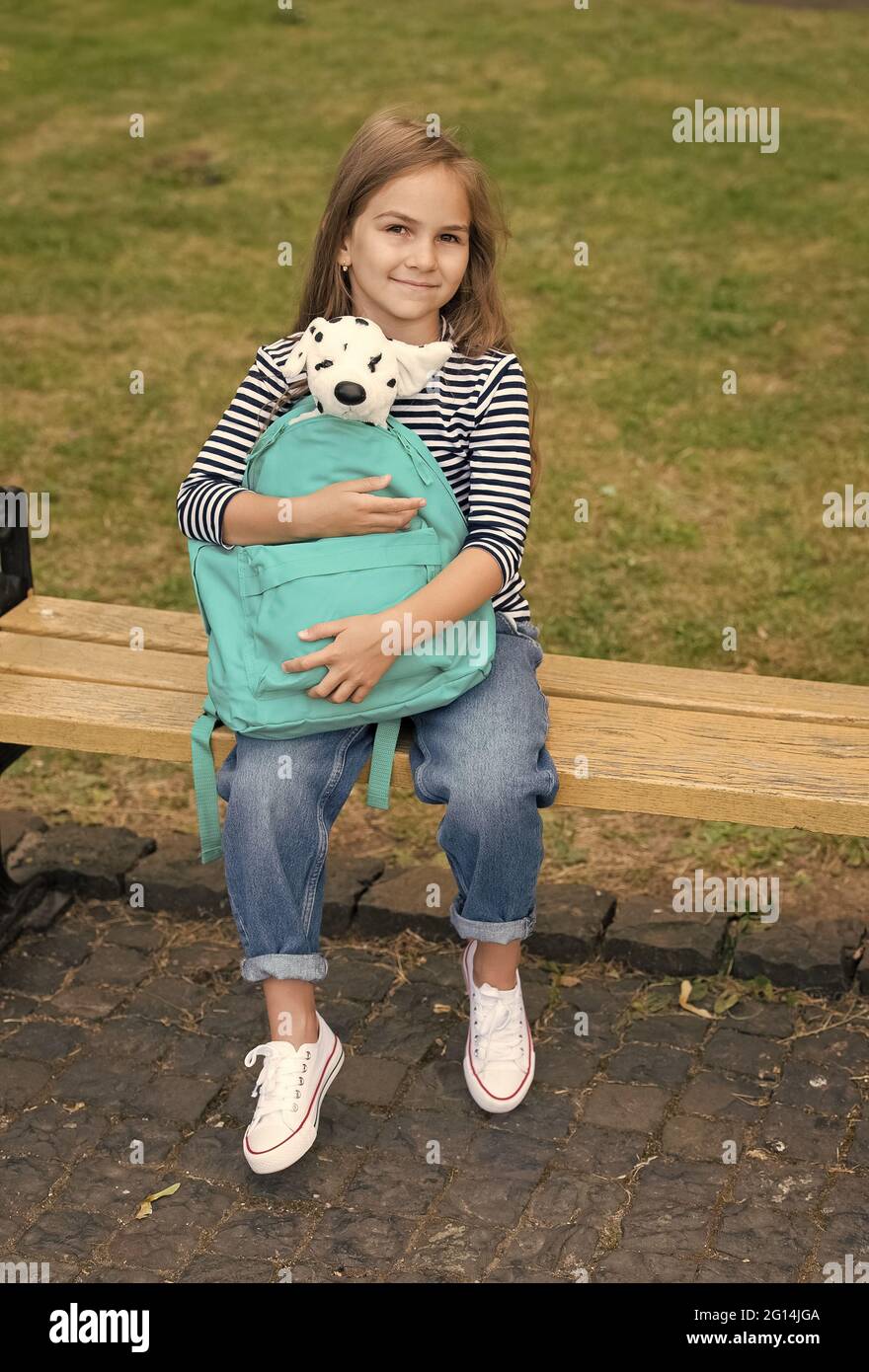 Play nice, stay kind. Preschool child hold toy dog in bag. Junior ...