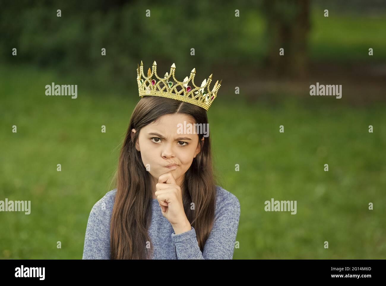 Cute girl golden crown outdoors green nature background, grumpy ...