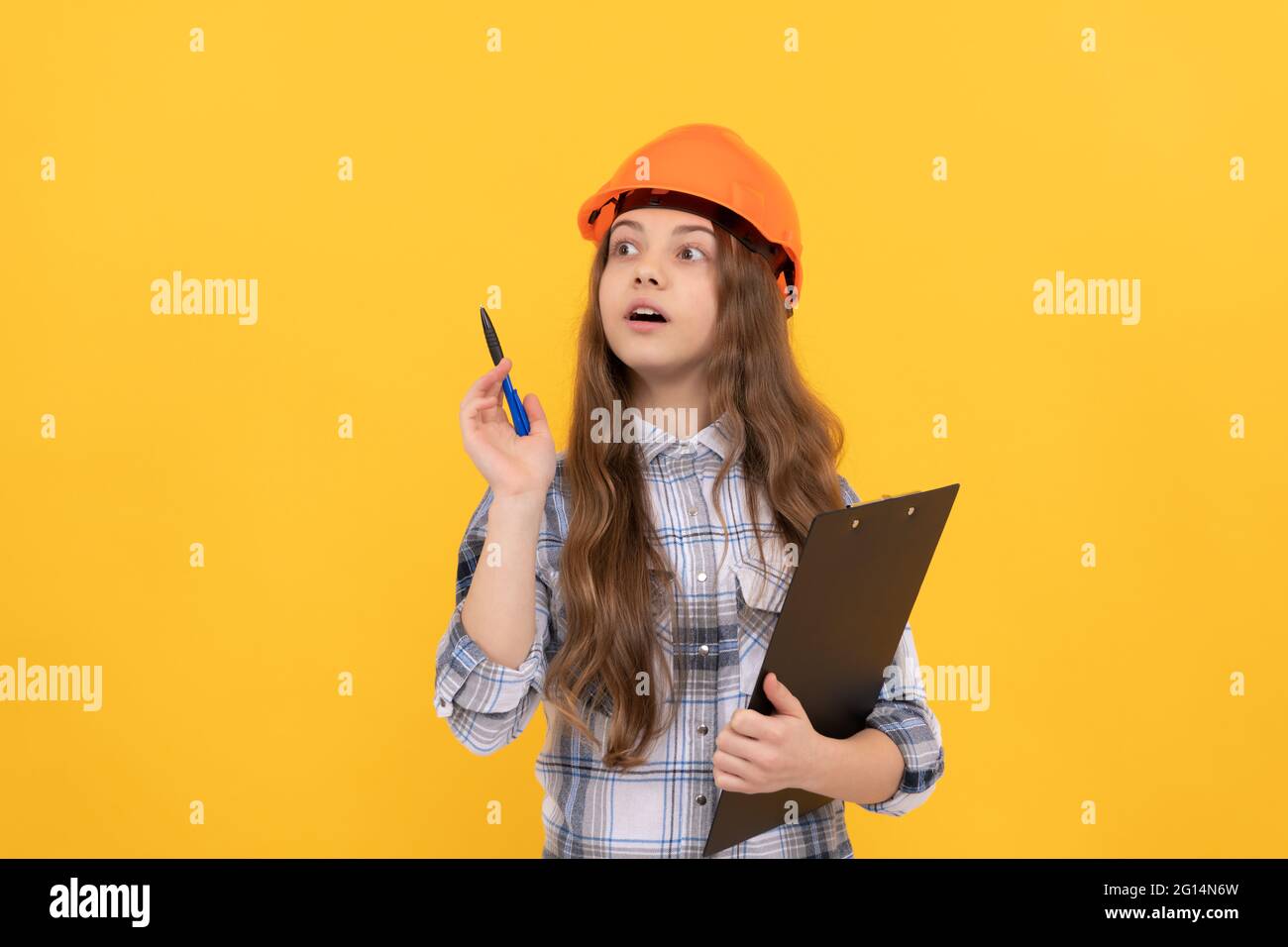 concentrated child worker wear hardhat hold clipboard. childhood ...
