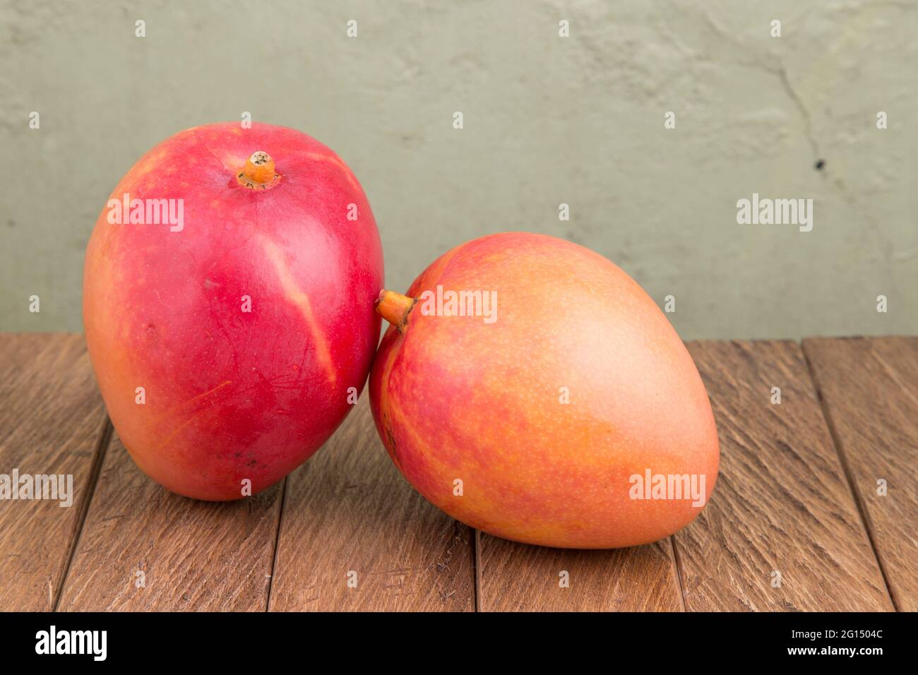 Delicious tommy mango on wooden table - Mangifera indica Stock Photo ...