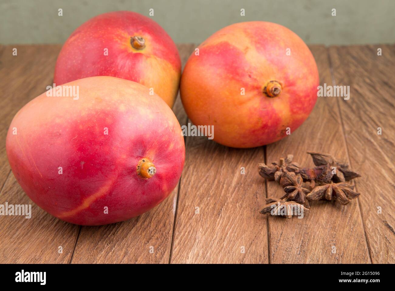 Delicious tommy mango on wooden table - Mangifera indica Stock Photo ...