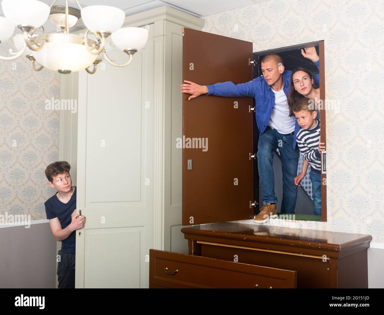 Interested family peeking into quest room through door above dresser ...
