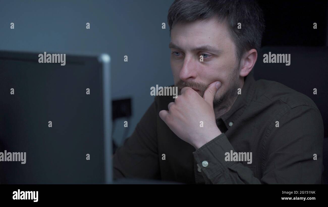 Young caucasian man working overtime at computer and eye fatigue from ...