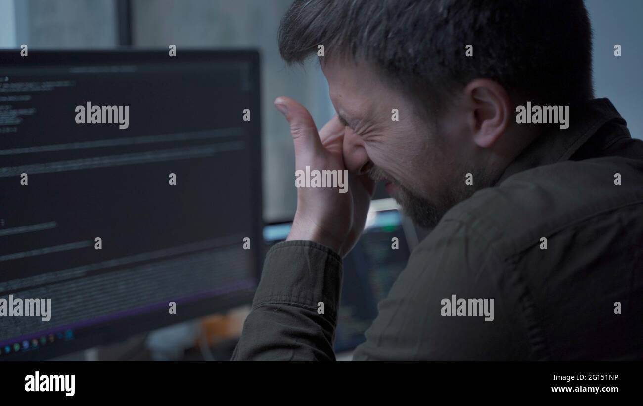 Tired male working on computer. Sad exhausted man at home office. Stressful work, stress at ...