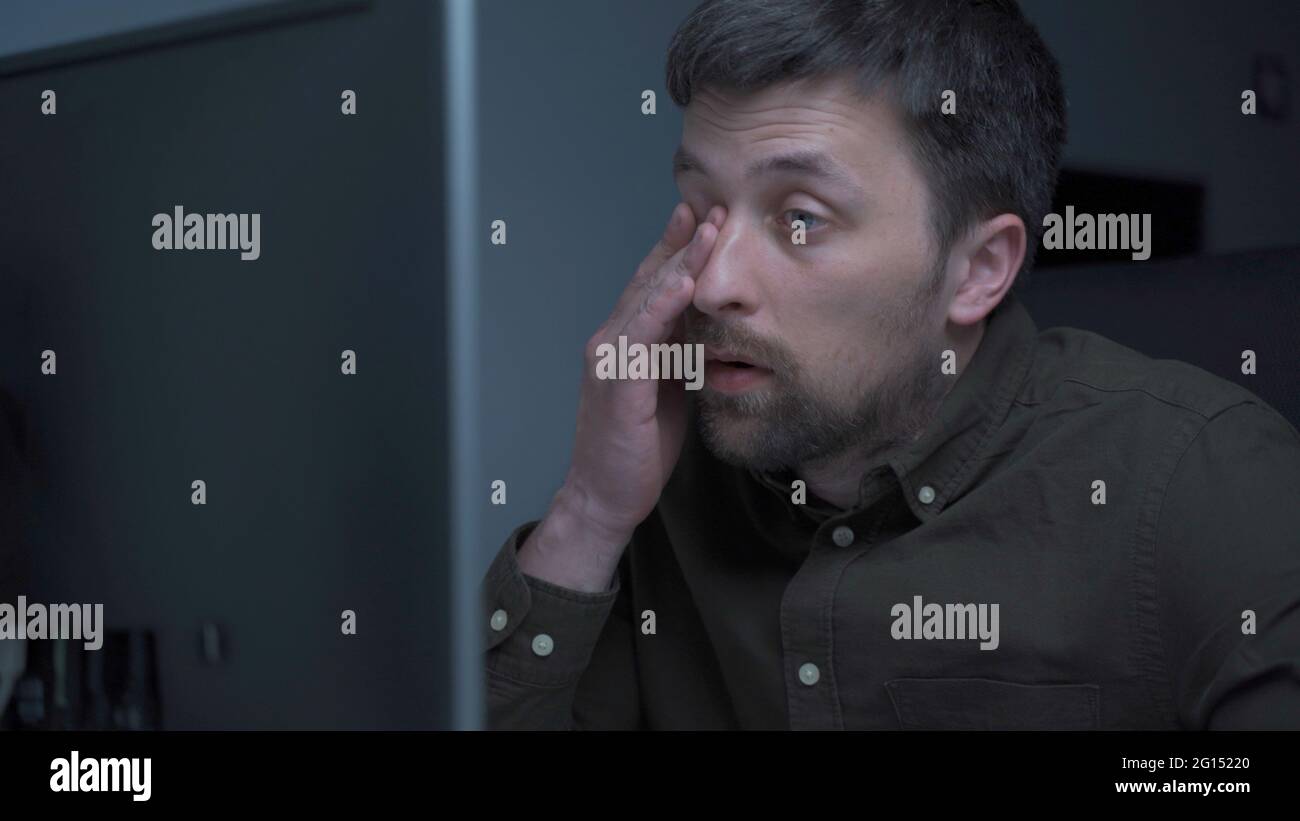 Tired male working on computer. Sad exhausted man at home office ...