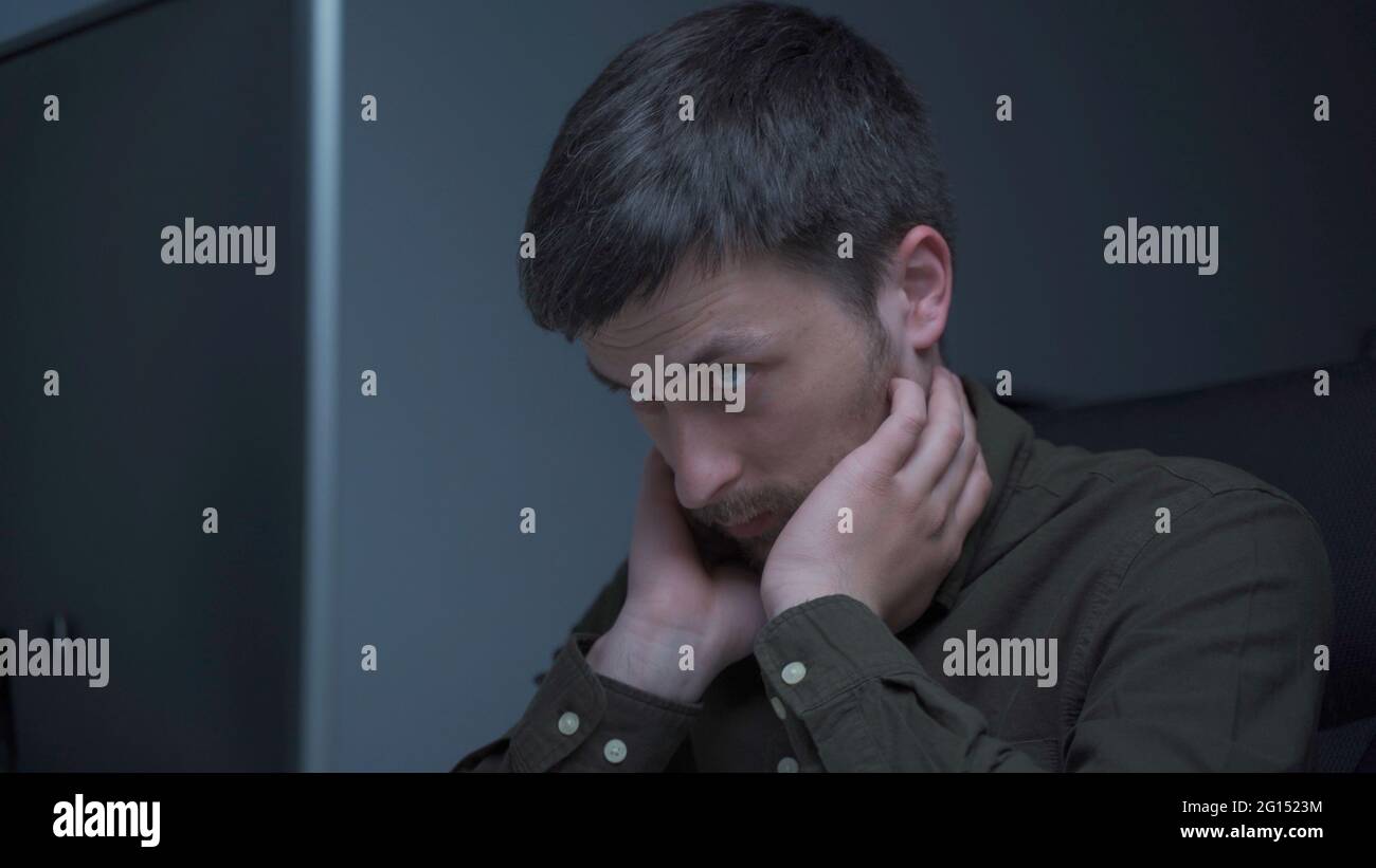 Young caucasian man working overtime at computer and eye fatigue from ...