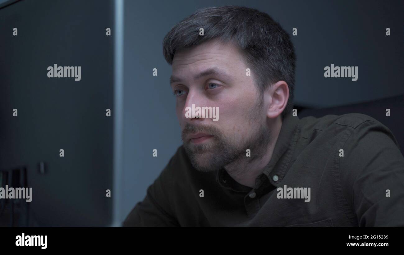 Young caucasian man working overtime at computer and eye fatigue from ...
