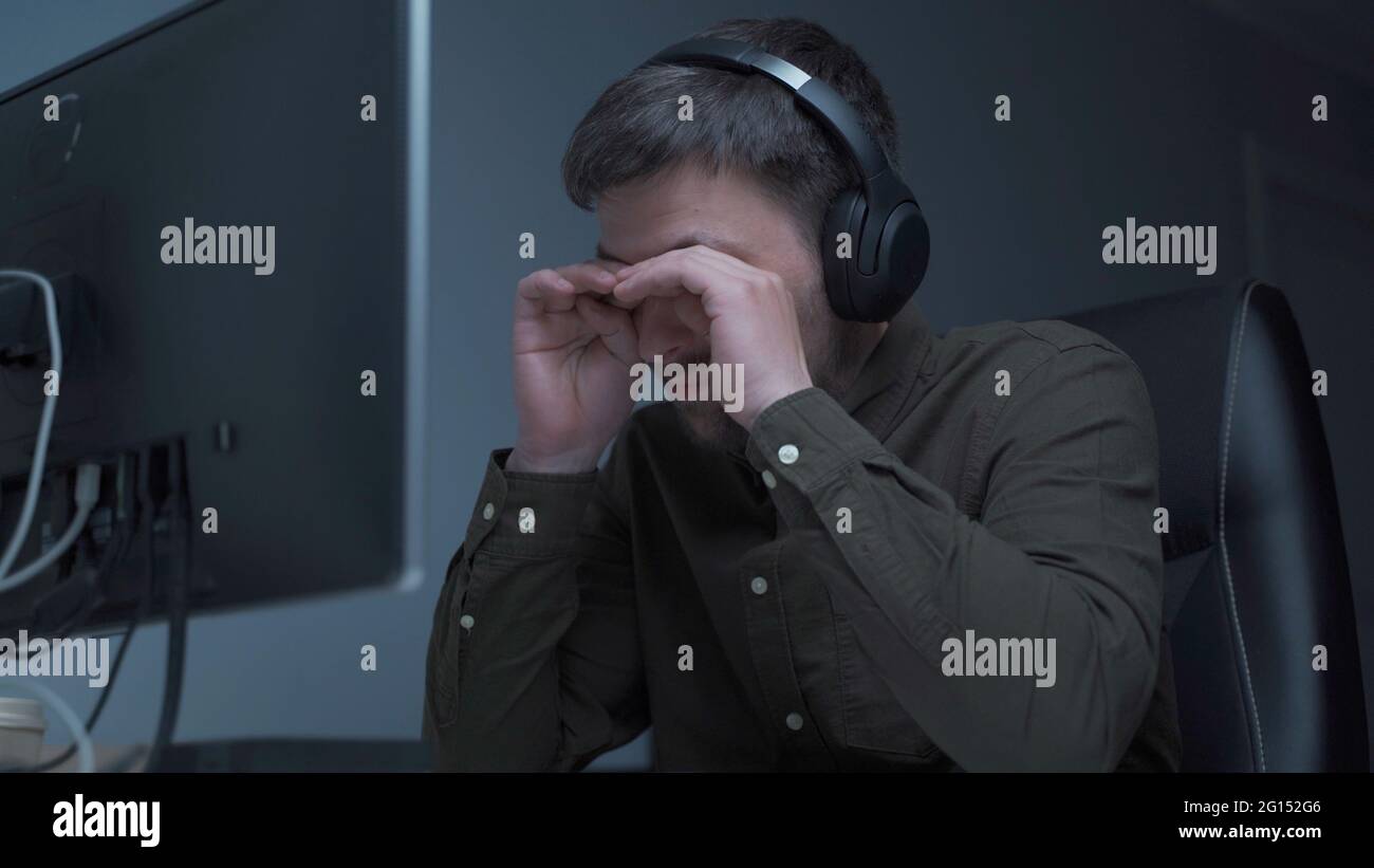 Tired male working on computer. Sad exhausted man at home office ...