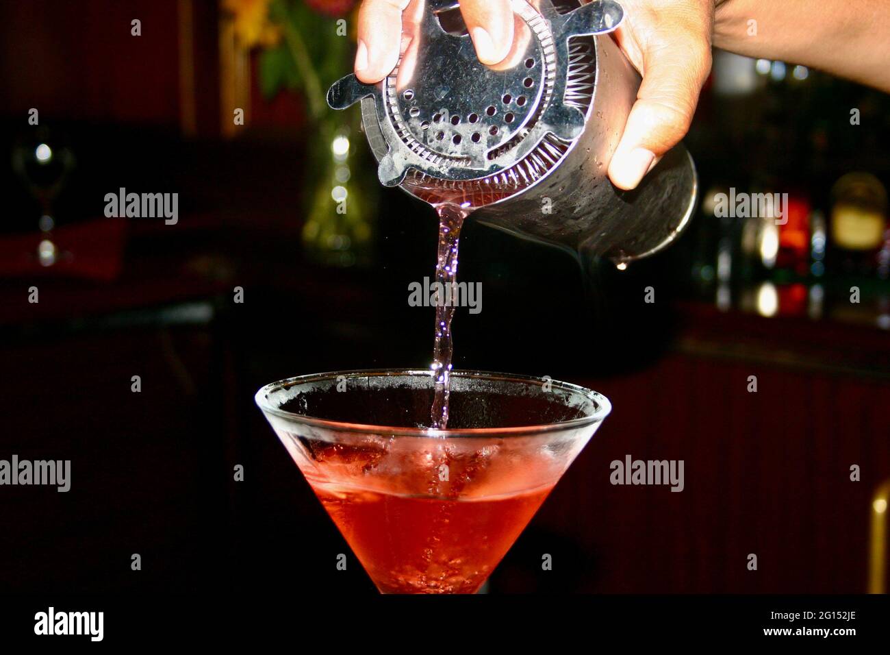 bartender pouring a cosmopolitan martini Stock Photo - Alamy