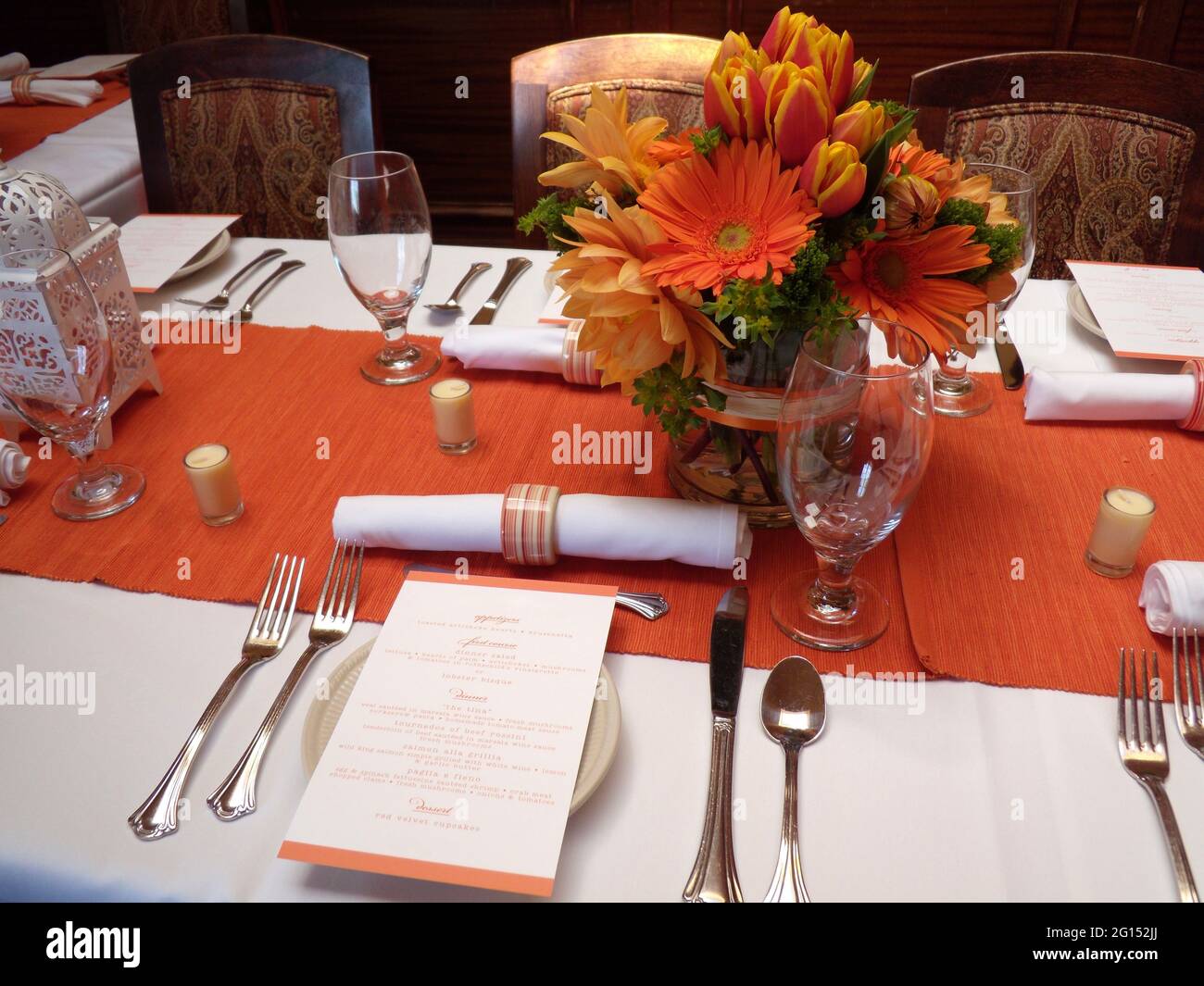 formal place setting at the table complete with flowers and candles ...