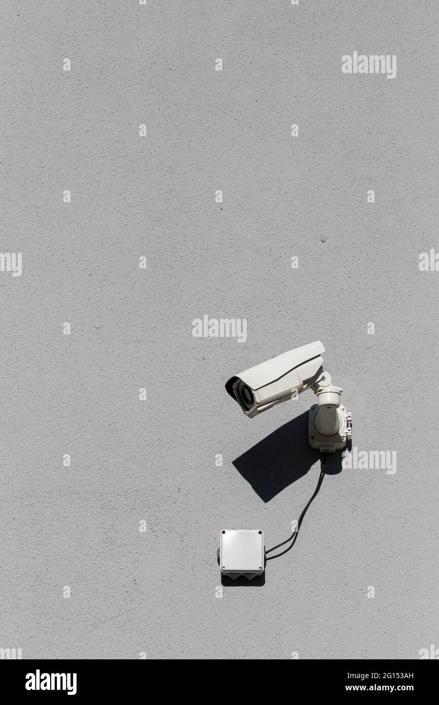 small white surveillance camera on flat gray matte plaster wall Stock ...
