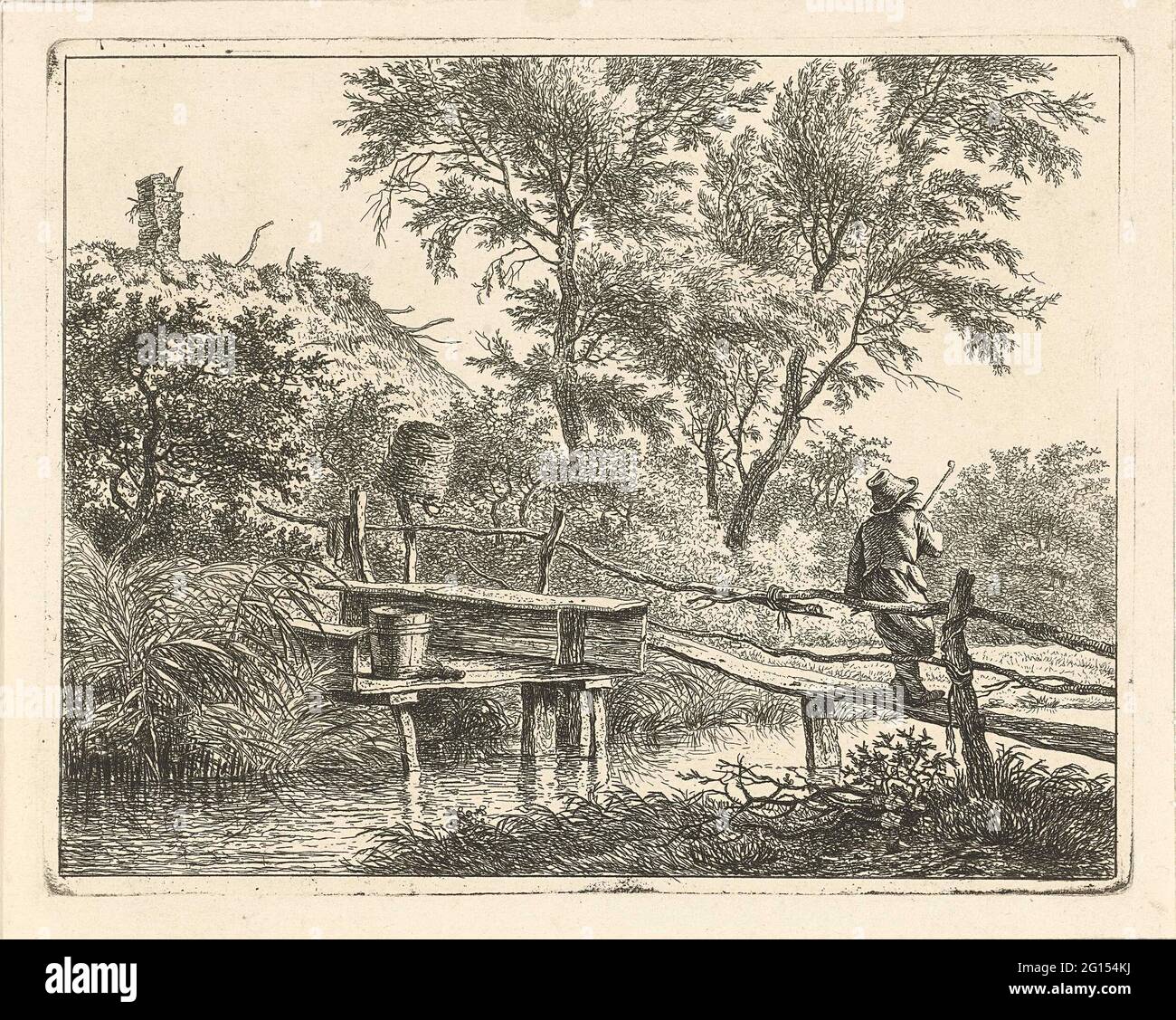 Man on bridge. A man stands on a narrow wooden bridge over a ditch. On ...