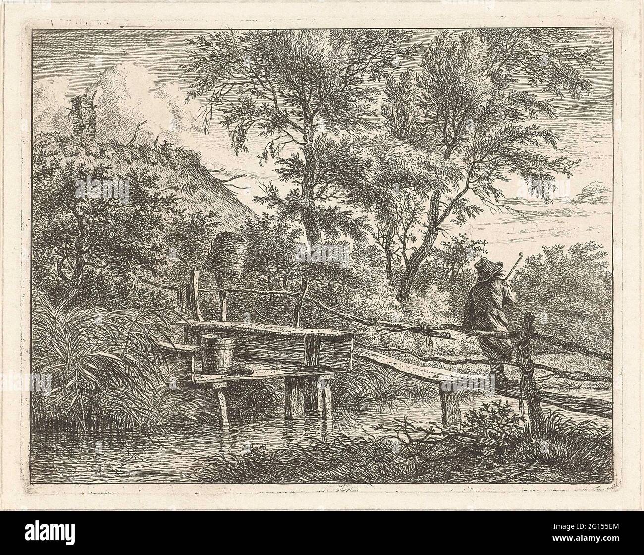Man on bridge. A man stands on a narrow wooden bridge over a ditch. On ...