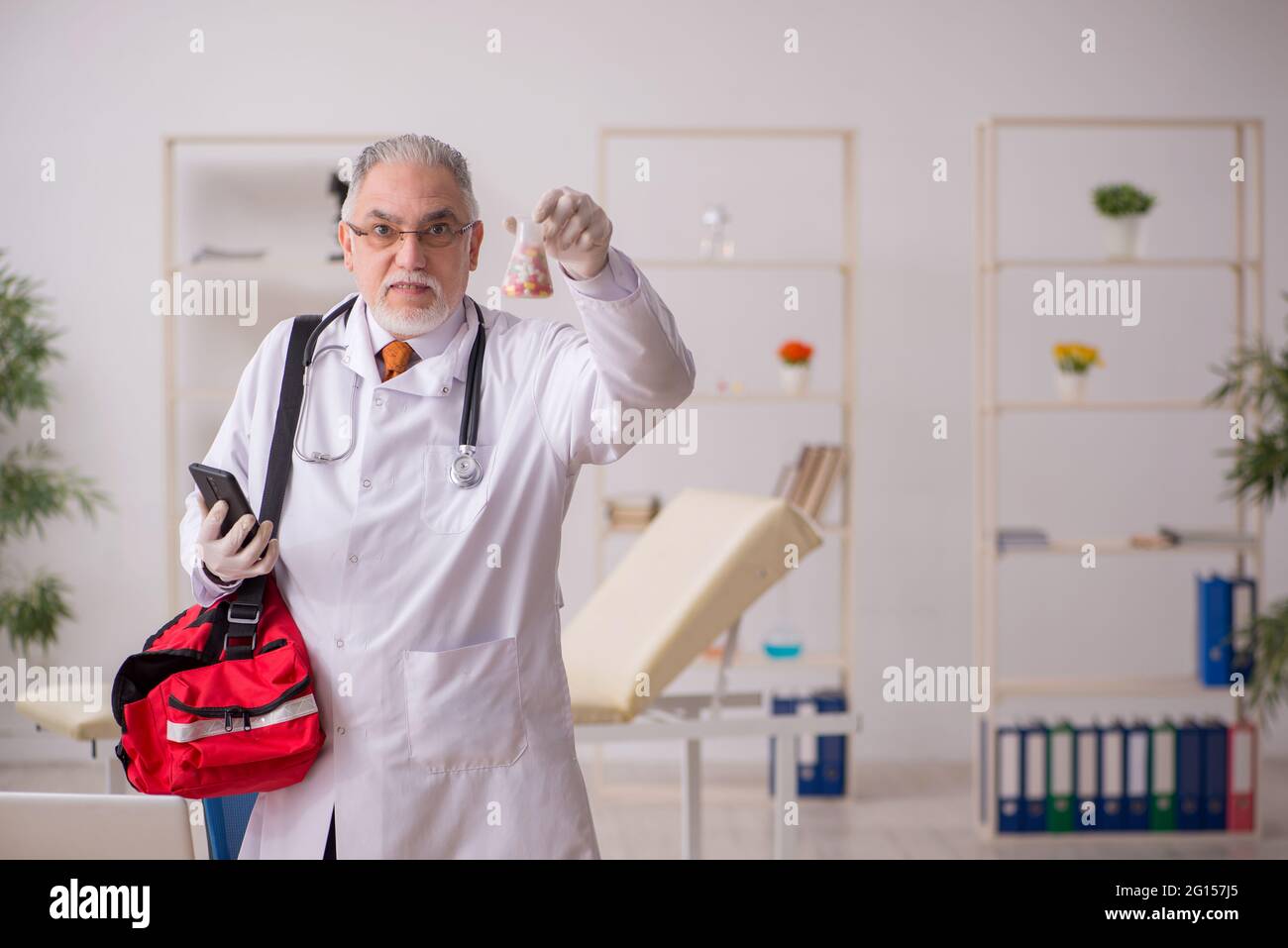 Old doctor in first aid concept Stock Photo - Alamy