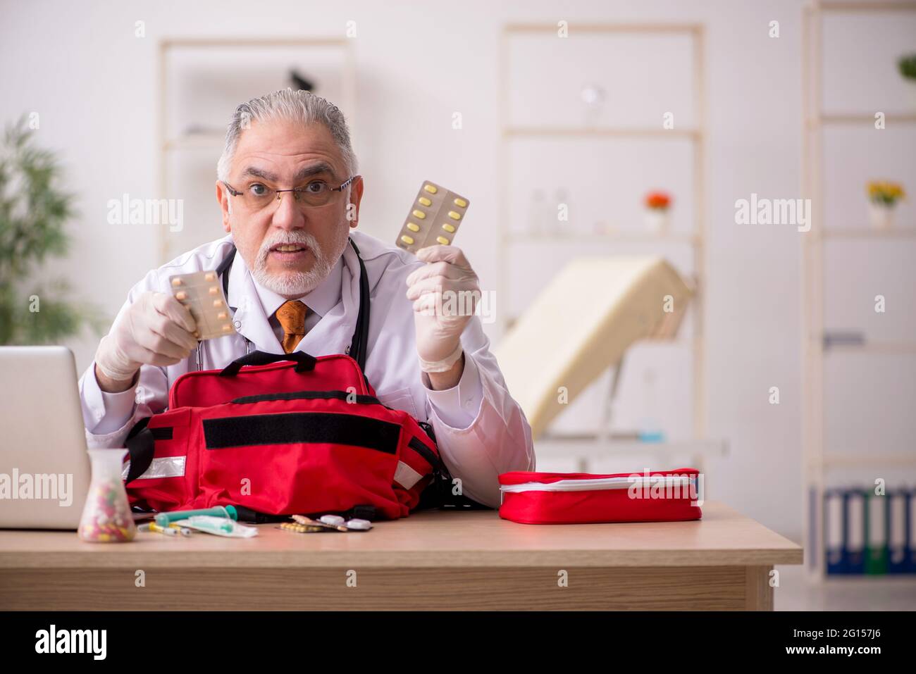 Old doctor in first aid concept Stock Photo - Alamy