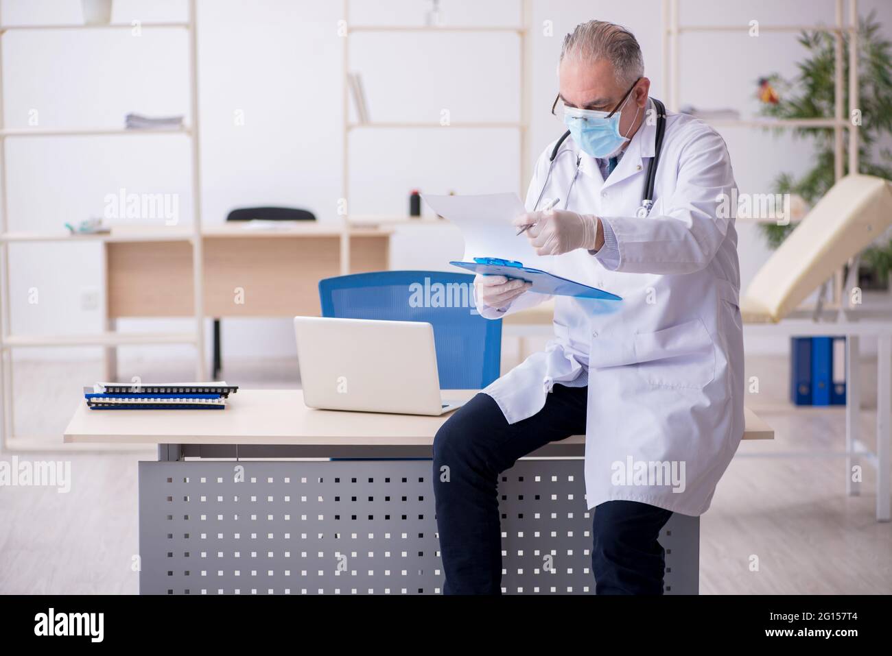 Old doctor working in the clinic Stock Photo - Alamy