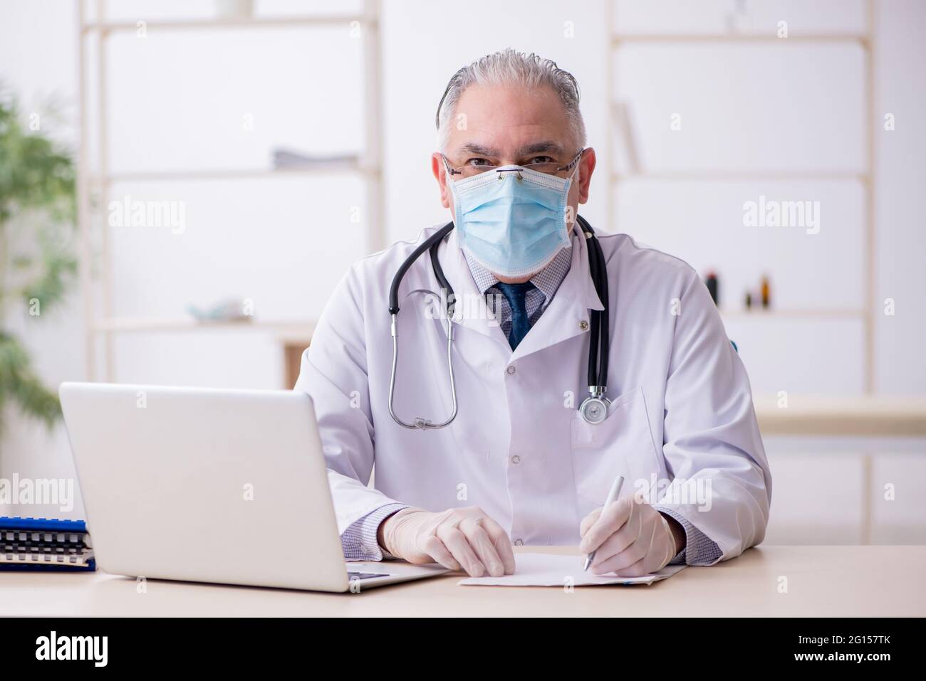Old doctor working in the clinic Stock Photo - Alamy