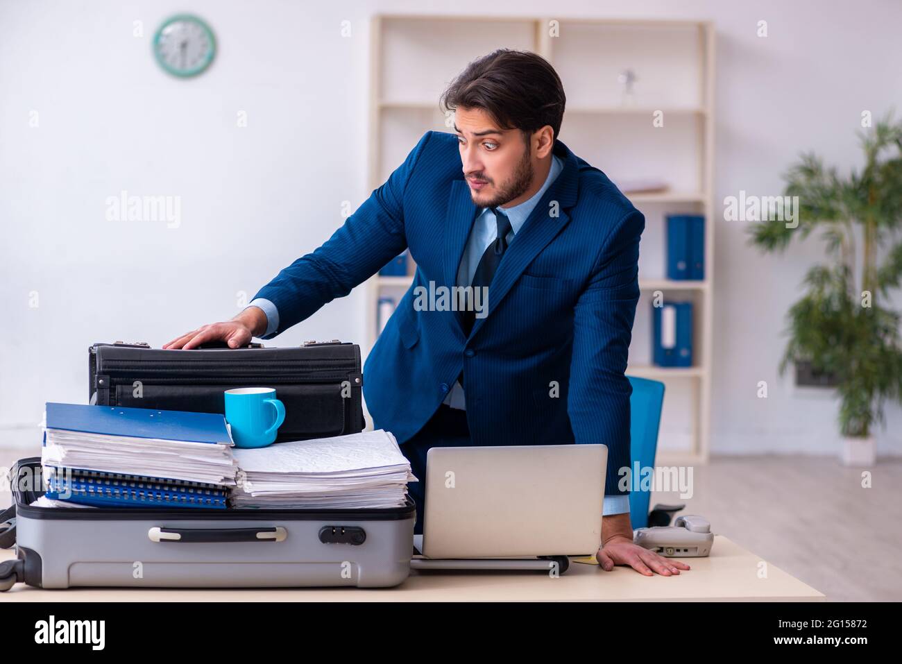 Young businessman employee preparing for business trip at workplace ...