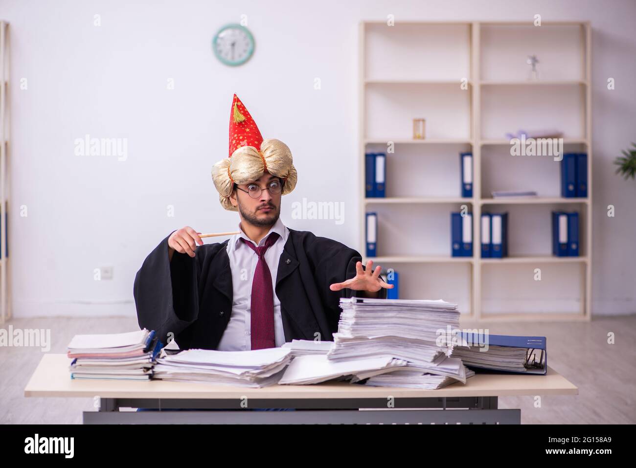 Funny young employee magician and too much work in the office Stock ...