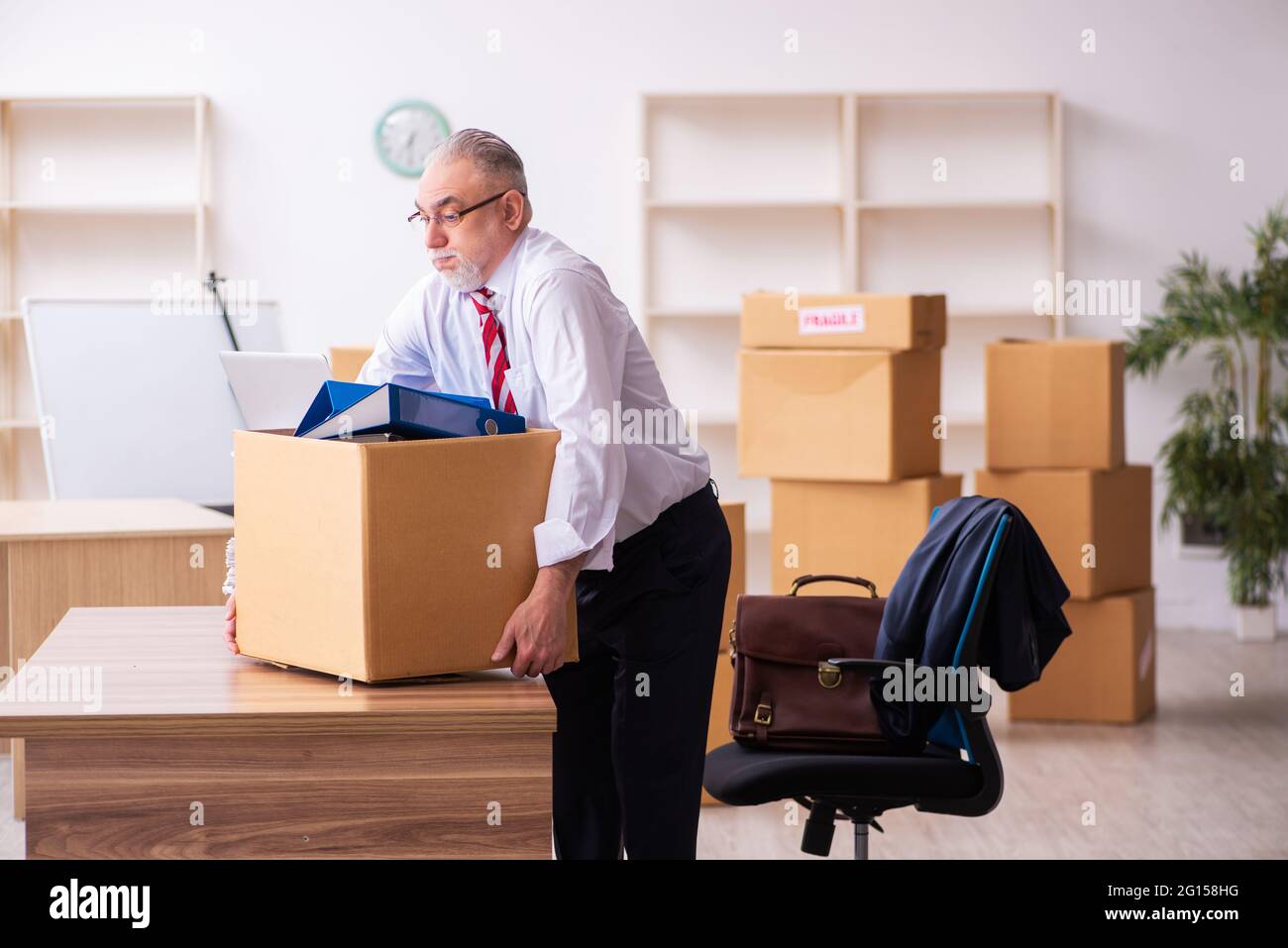 Old male employee in relocation concept Stock Photo - Alamy