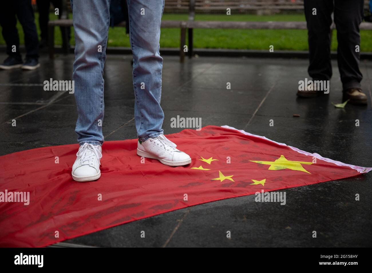 London, UK. 4th June 2021. A protester steps on the Chinese flag. Yuen ...
