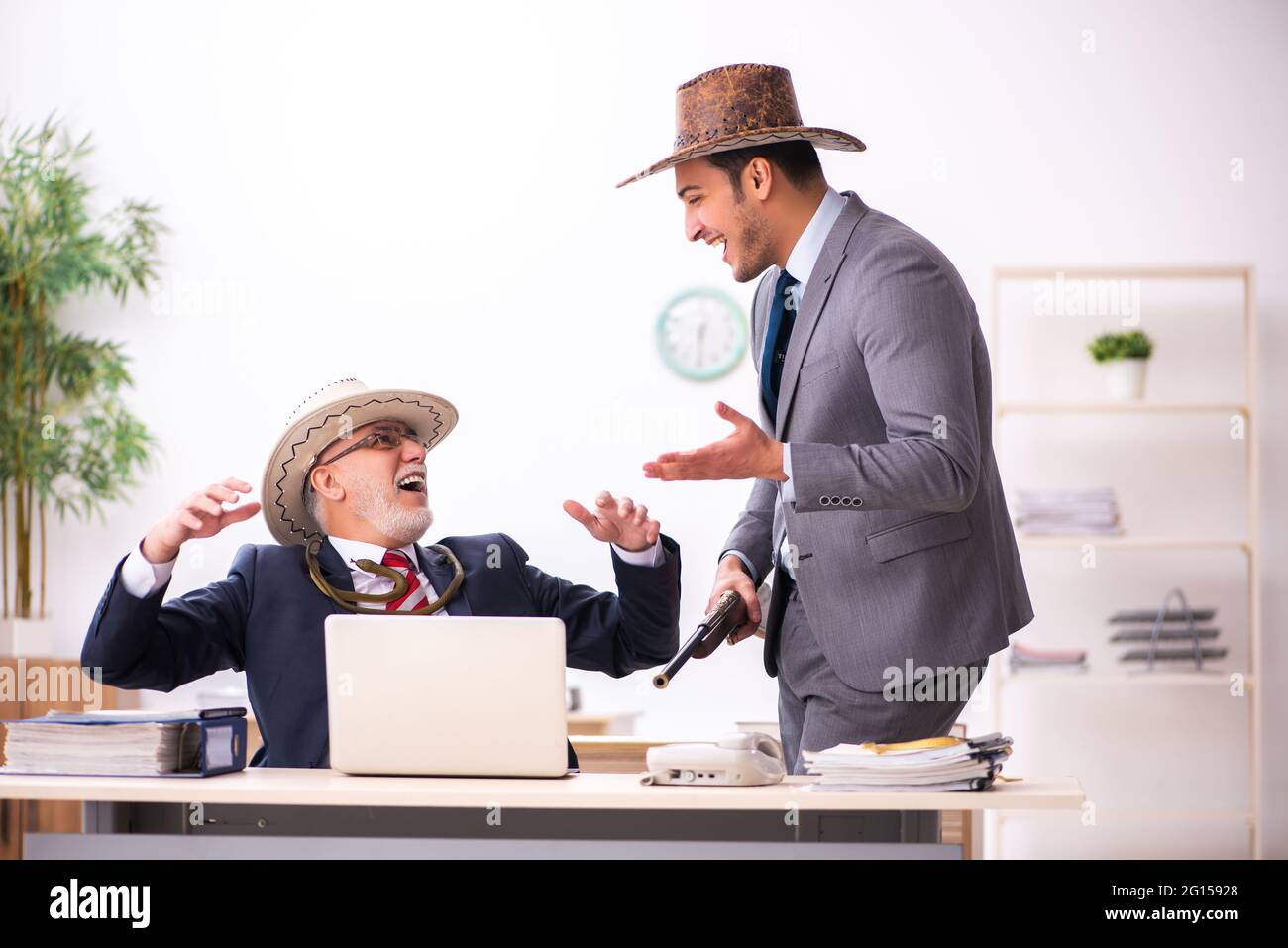 Two cowboy employees in funny concept Stock Photo - Alamy