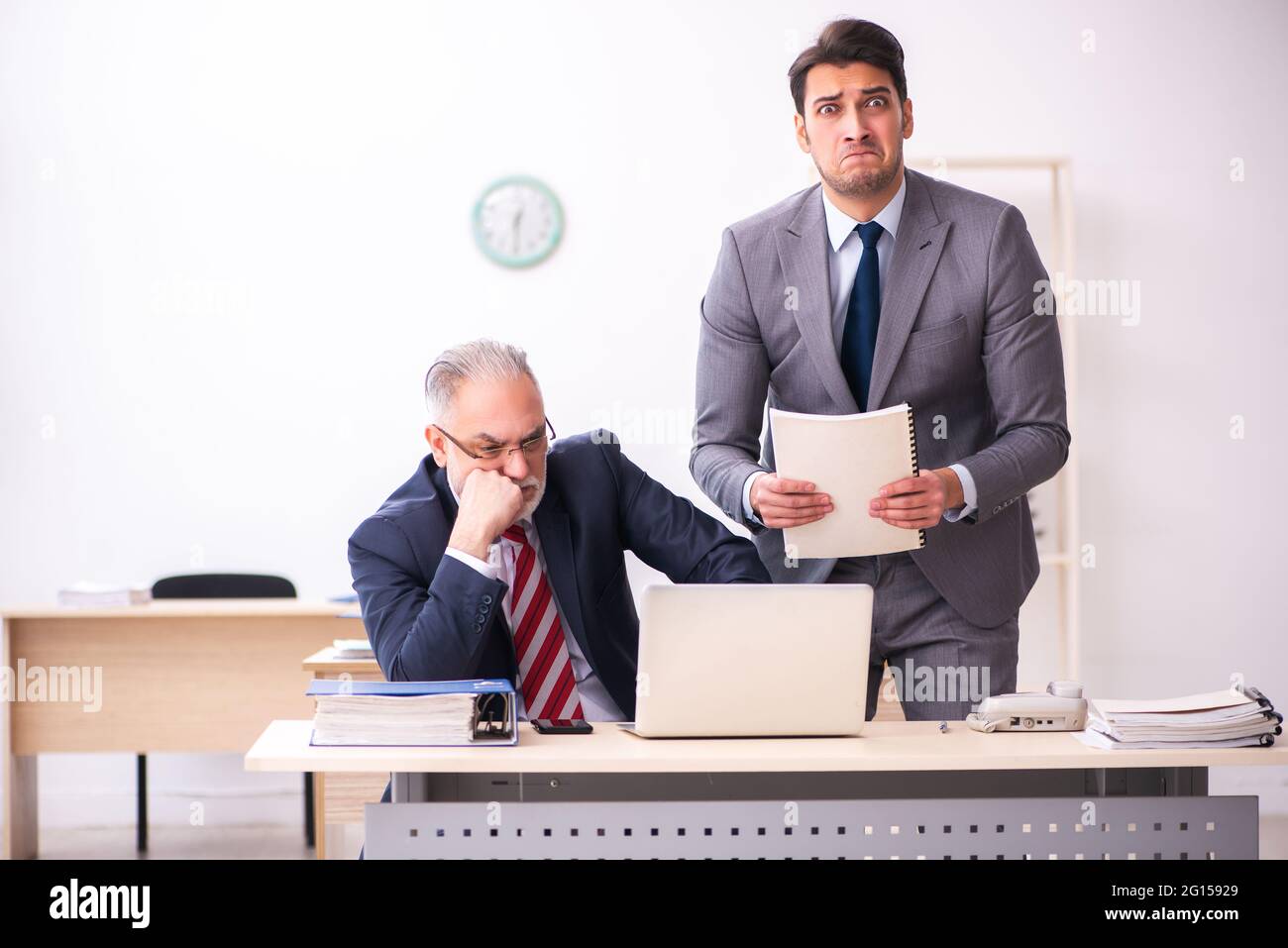 Old boss and young employee working at workplace Stock Photo - Alamy