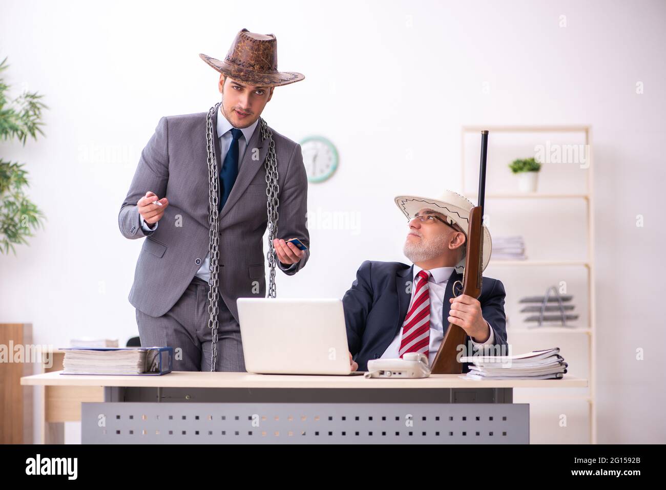 Two cowboy employees in funny concept Stock Photo - Alamy
