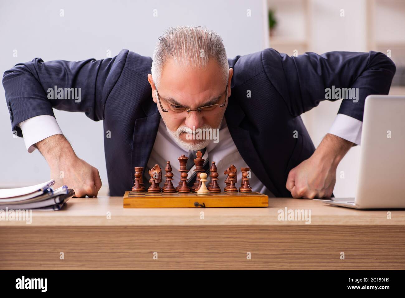 Old businessman employee playing chess at workplace Stock Photo - Alamy