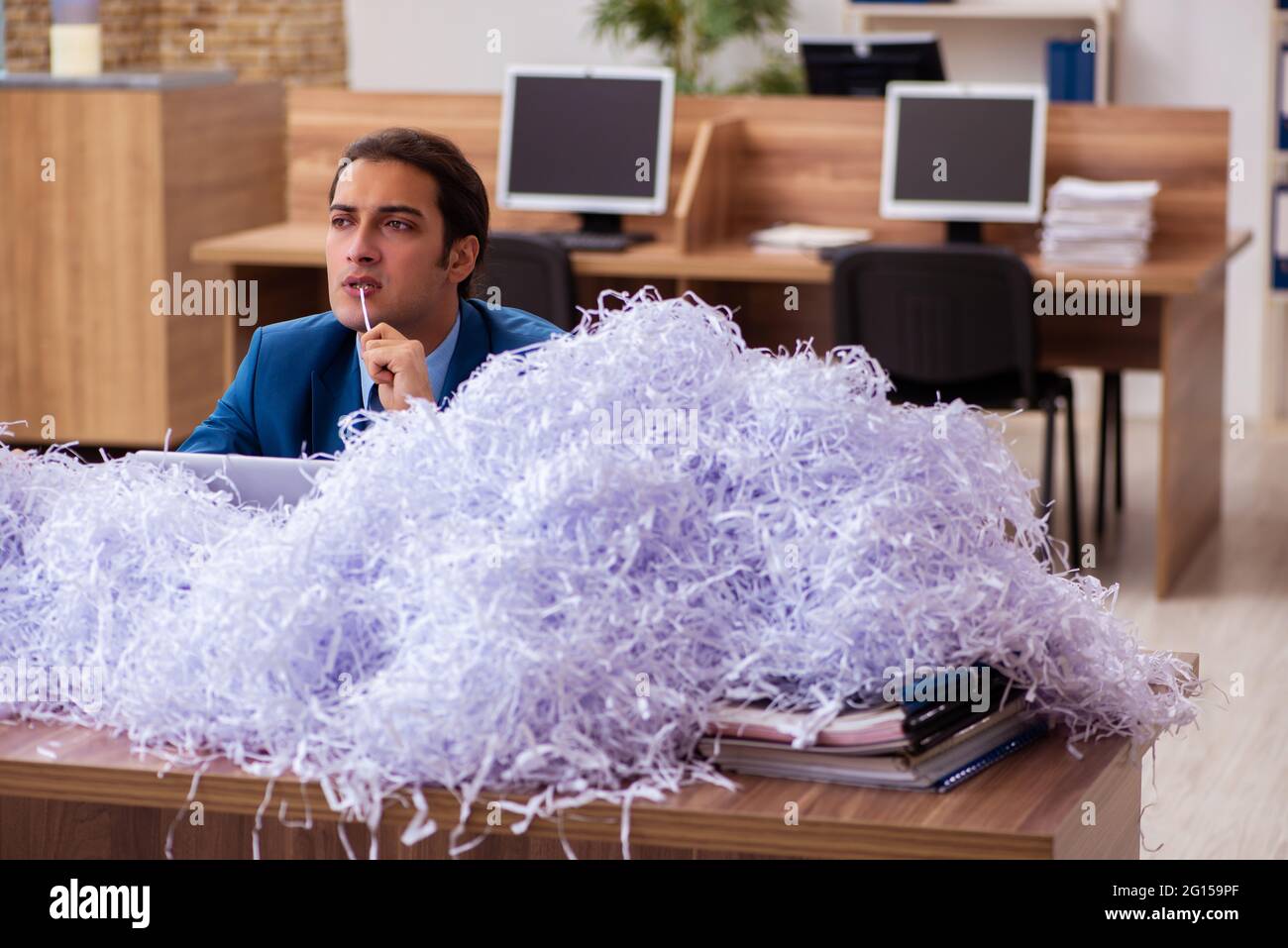 Young businessman employee and a lot of cut papers in the office Stock ...