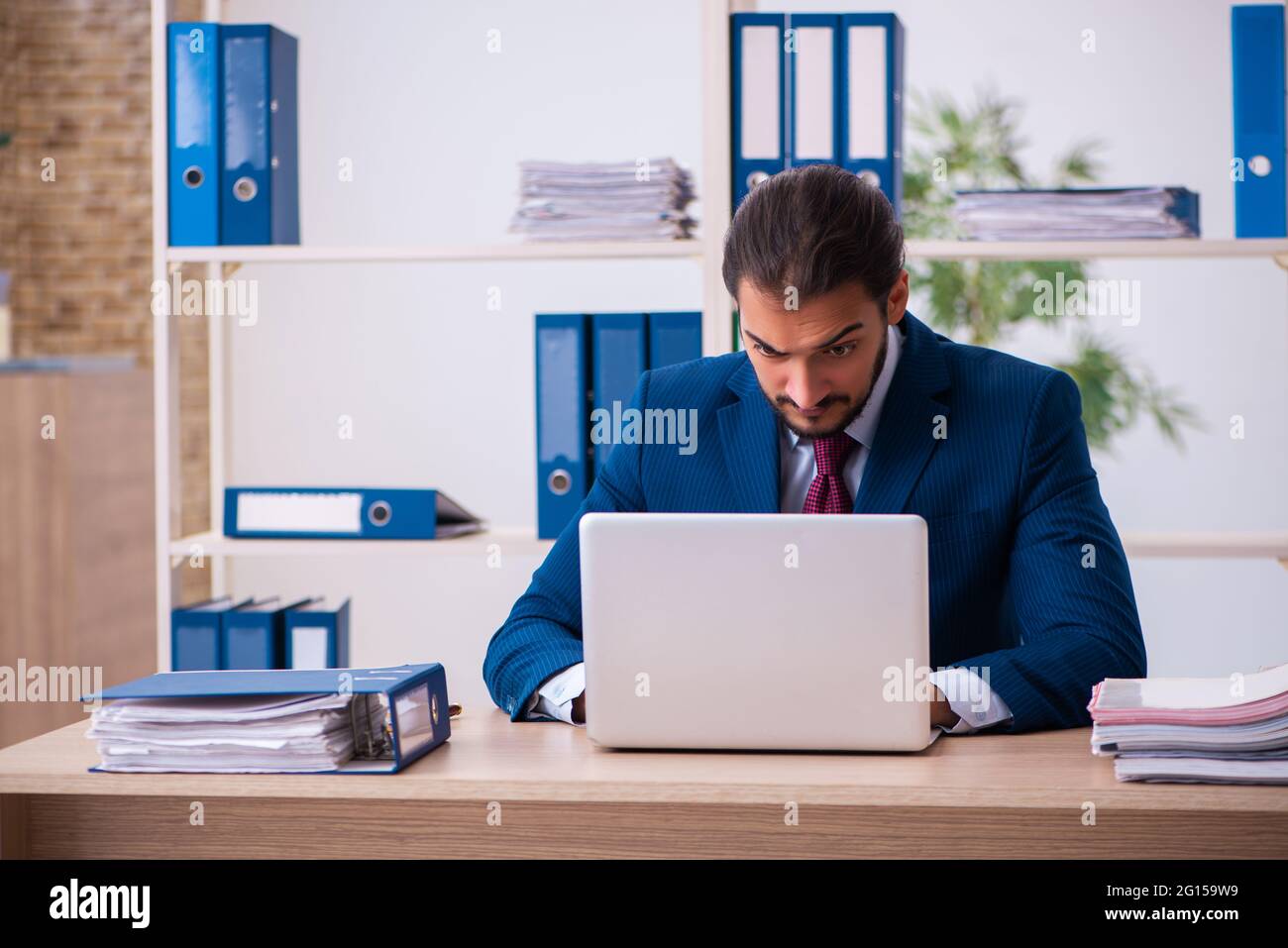 Young employee and too many work in the office Stock Photo - Alamy