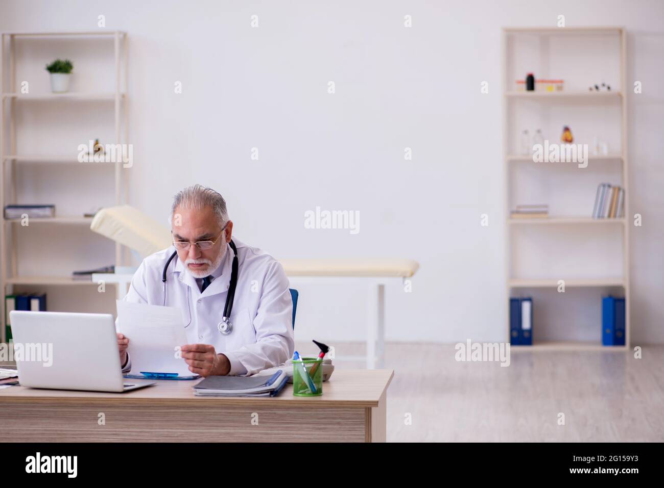 Old male doctor working in the hospital Stock Photo - Alamy
