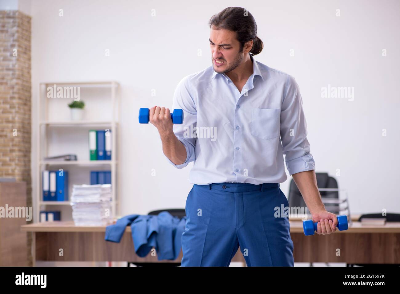 Young employee doing sport exercises during break Stock Photo - Alamy