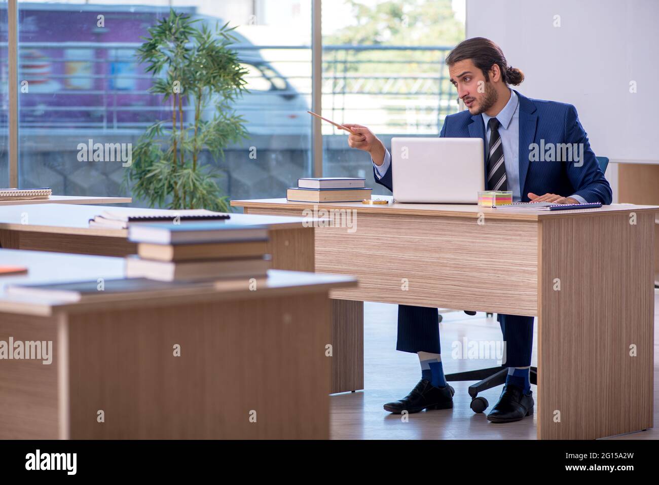 Young teacher in suit in the classroom Stock Photo - Alamy