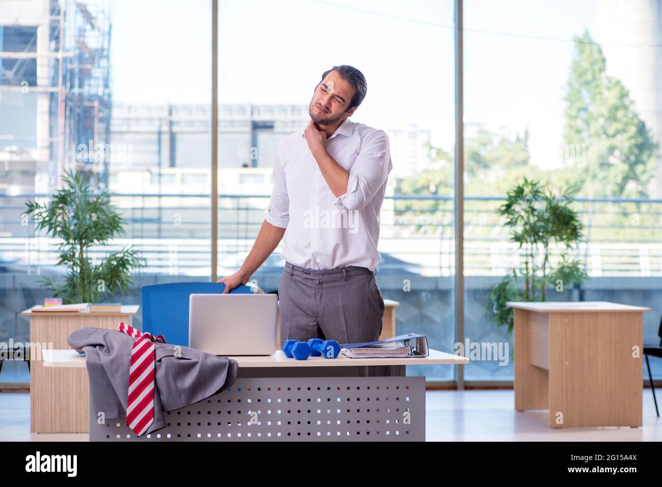 Young employee doing sport exercises at workplace Stock Photo - Alamy