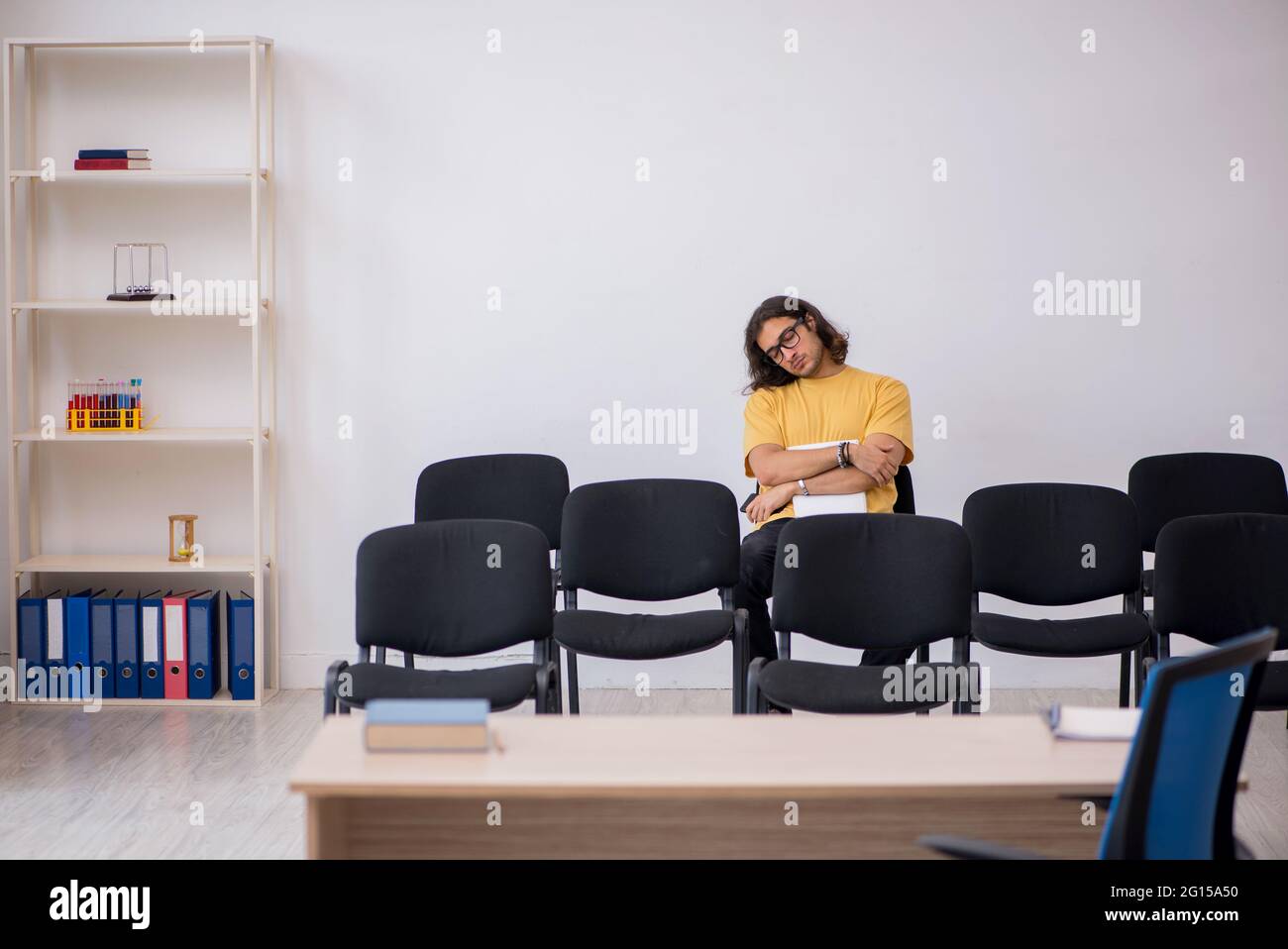 Young student waiting for teacher in the classroom Stock Photo - Alamy