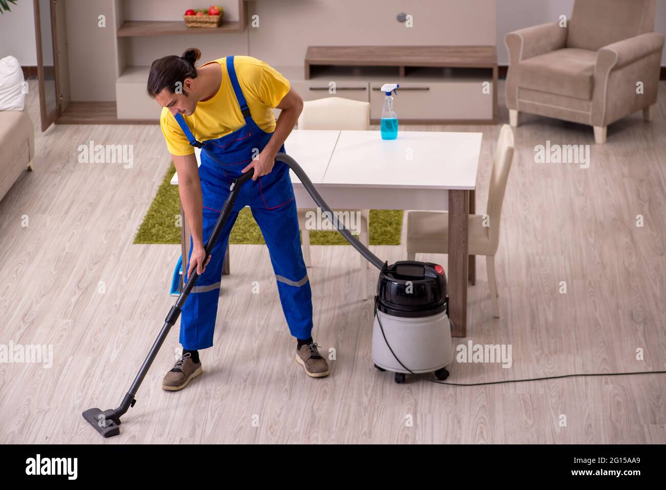 Young contractor cleaning the house Stock Photo - Alamy