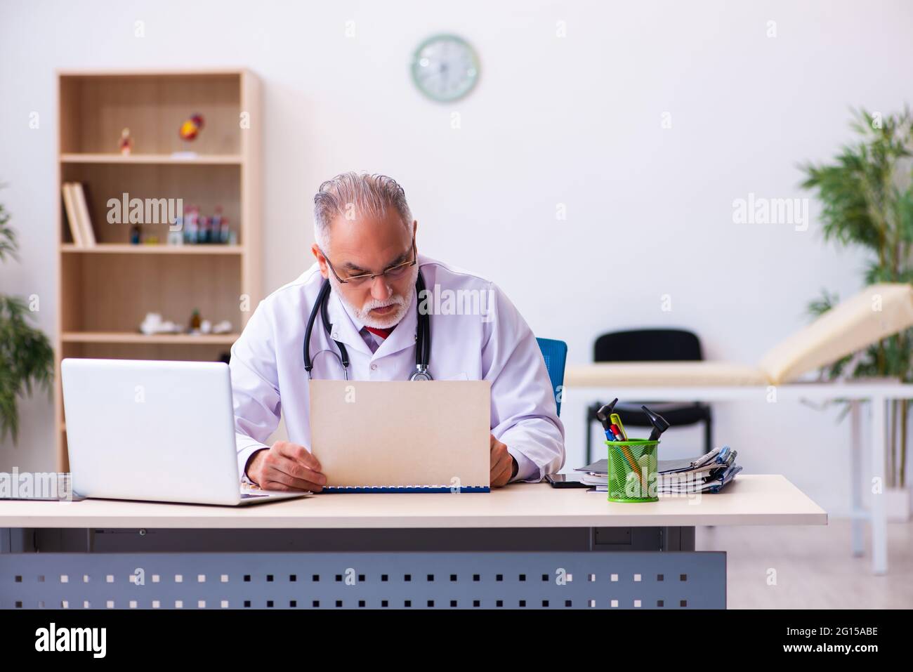 Old doctor working in the clinic Stock Photo - Alamy